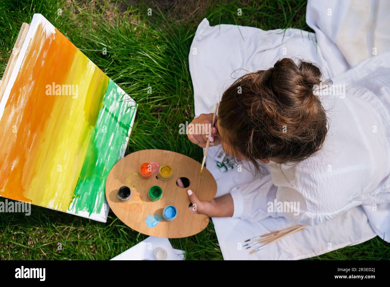 Artist painting on the easel outdoors in the garden. Open air outdoor ...