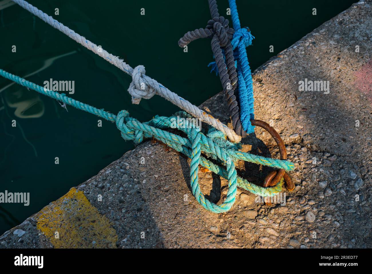 Mooring ring with tied blue and white nautical rope mounted on a ...