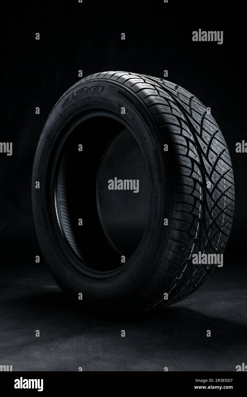 Brand new modern car tyre on a black background. Studio shot Stock ...