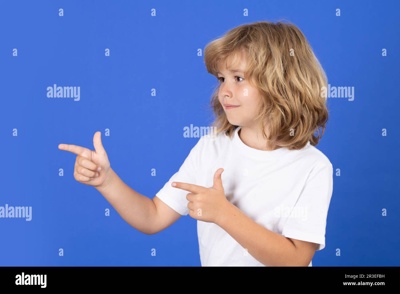 Cute child pointing finger on isolated studio background. Kid pointing ...
