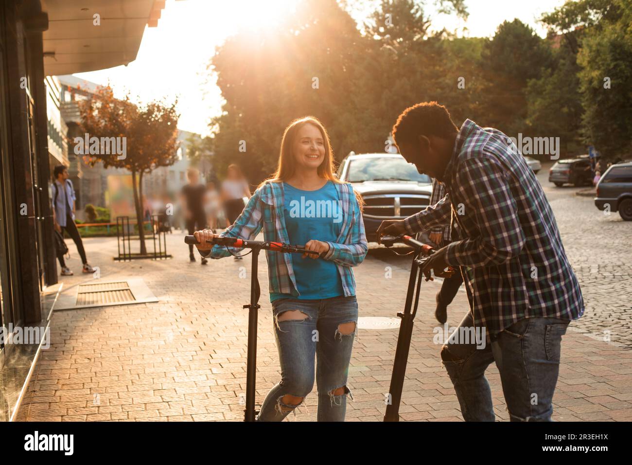 The young couple having fun while riding scooters Stock Photo - Alamy