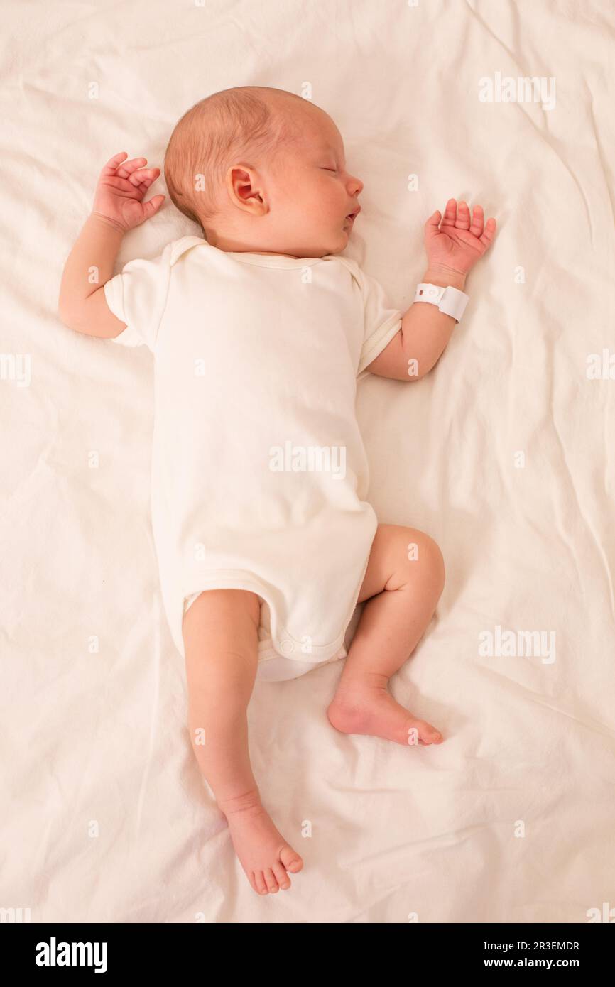 The newborn baby sleeps on the bed in the maternity hospital Stock ...