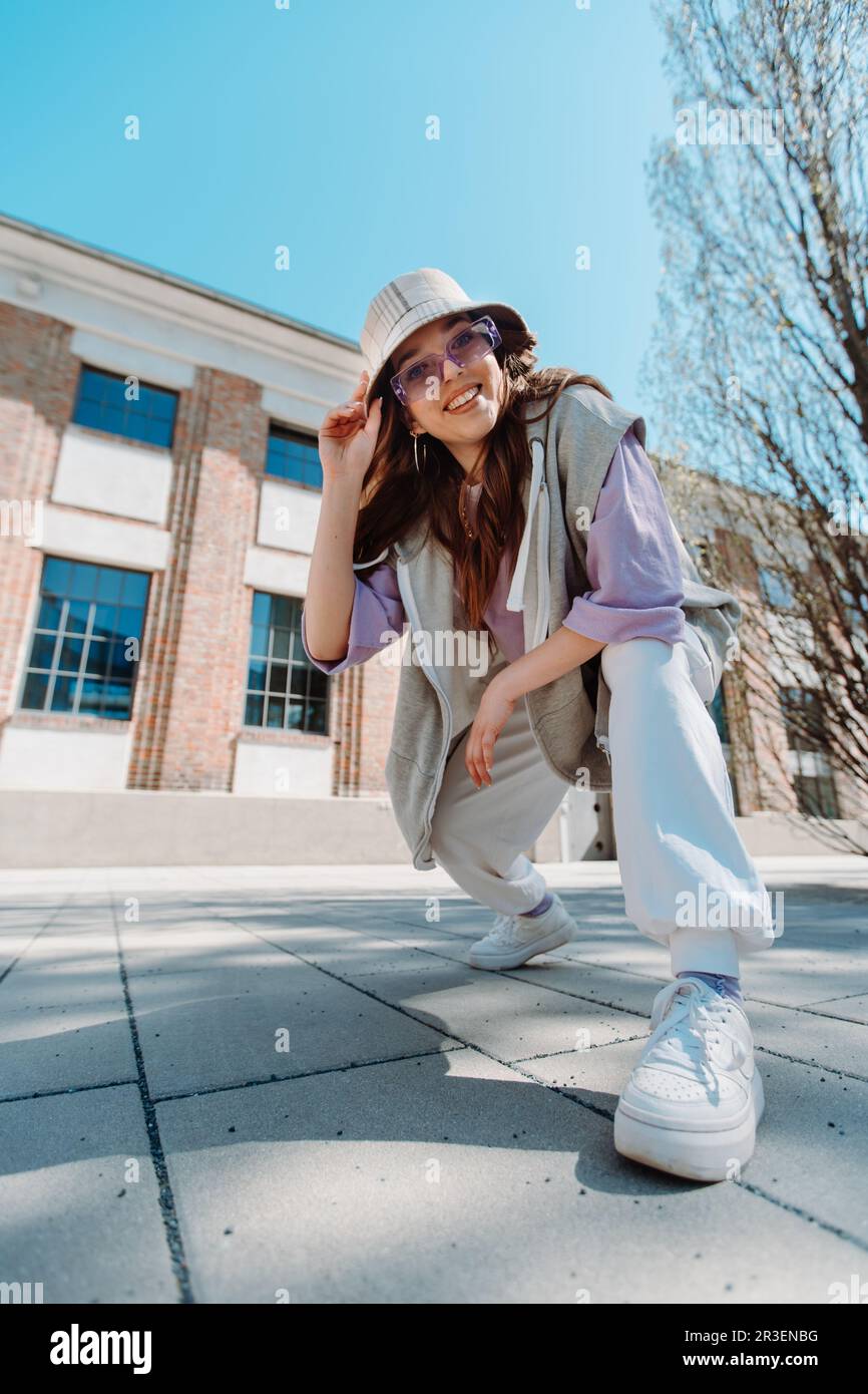 Young hip hop girl in oversize outfit wearing dancing into music ...