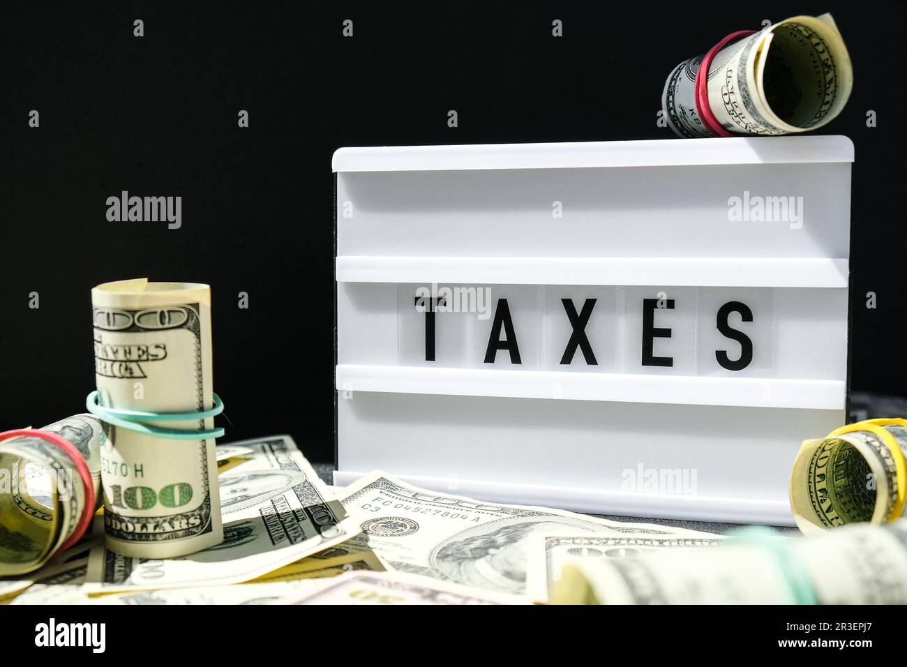 Lightbox board with word TAXES in black letters around Us Dollars ...