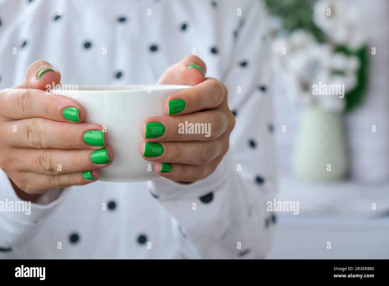 Manicured female hands with stylish green nails holding cup of coffee ...