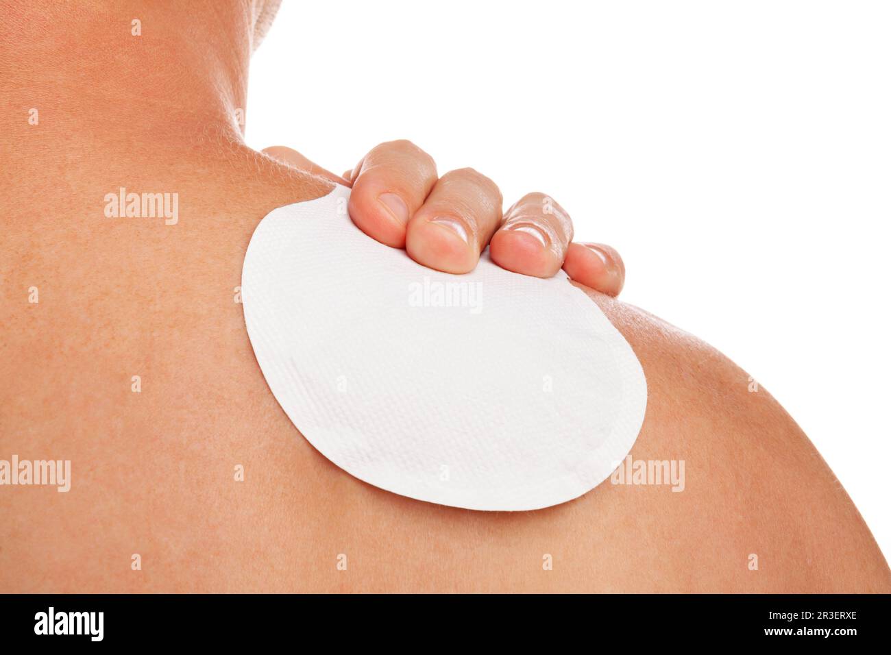 Young man applaying a heat patch for shoulder pain Stock Photo - Alamy