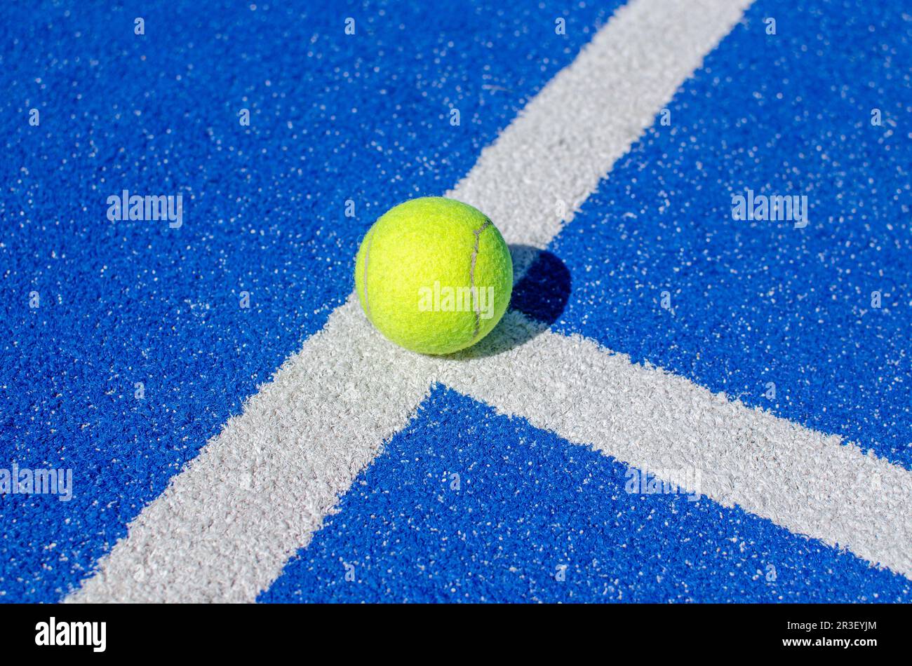 ball on the line of a blue paddle tennis court Stock Photo - Alamy