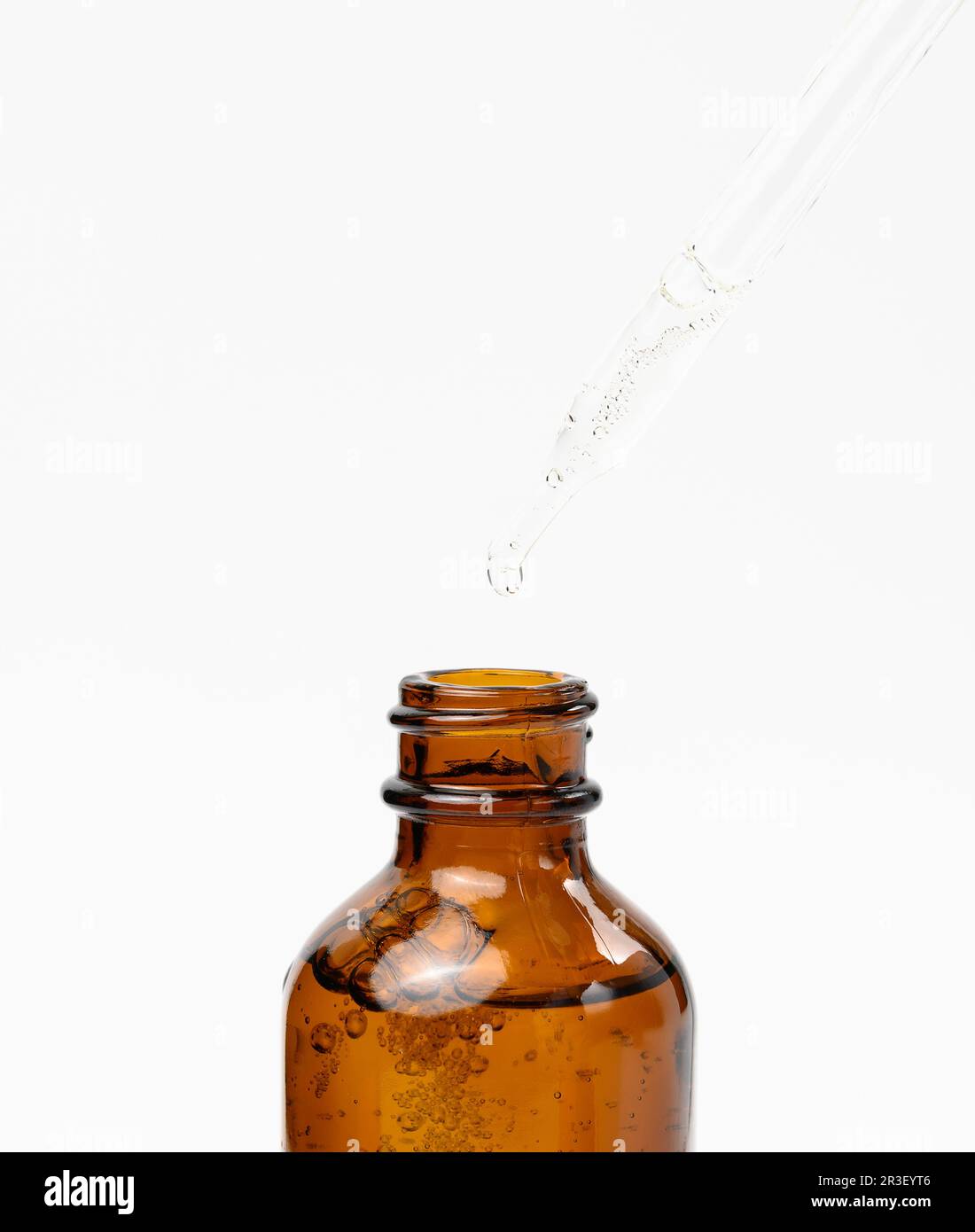 Essential oil falling from the amber glass dropper. Blue bottle of ...