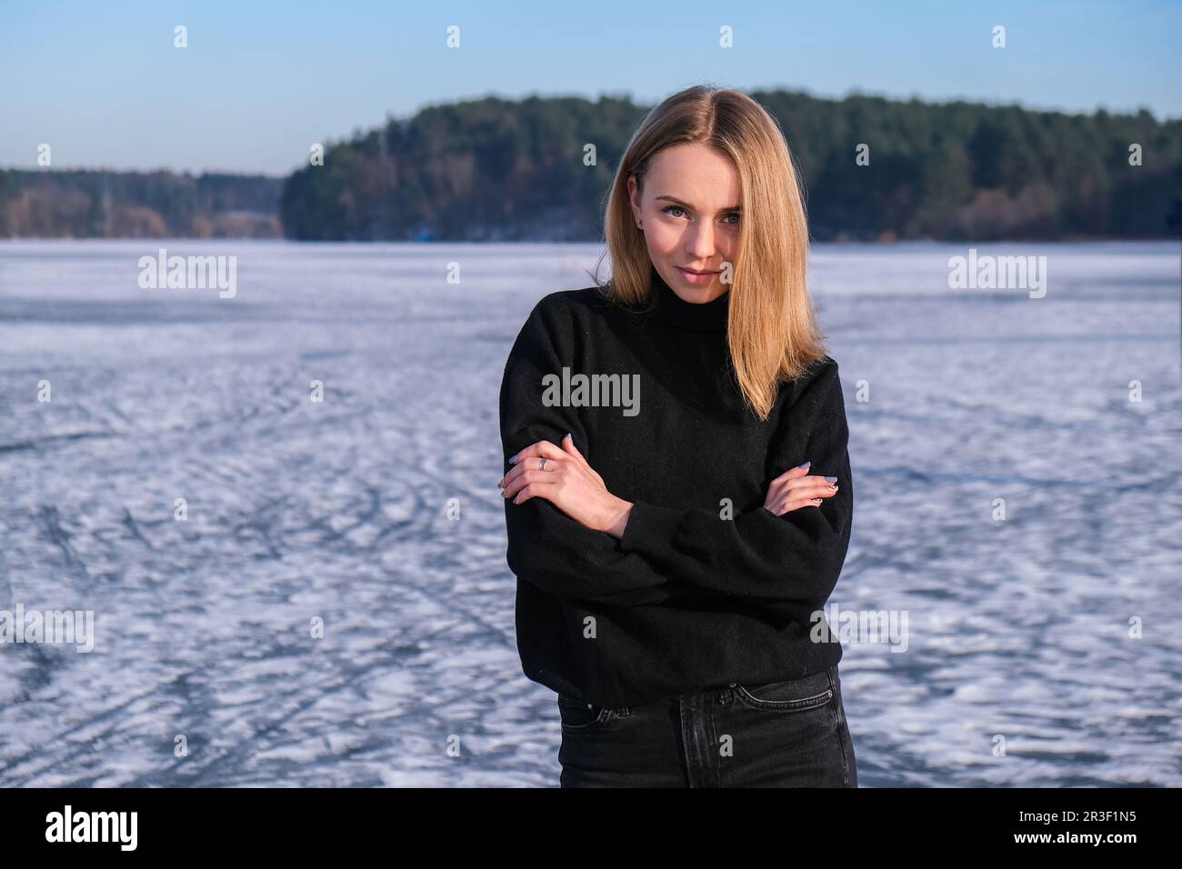 Young female smiling and looking at a camera in a snow landscape. Happy ...