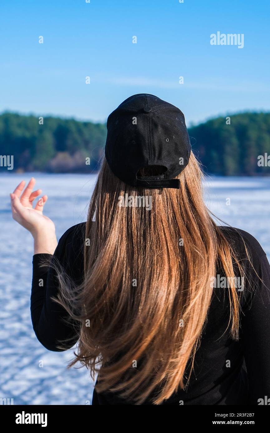 Young female woman back to the camera with long hair in a snow ...