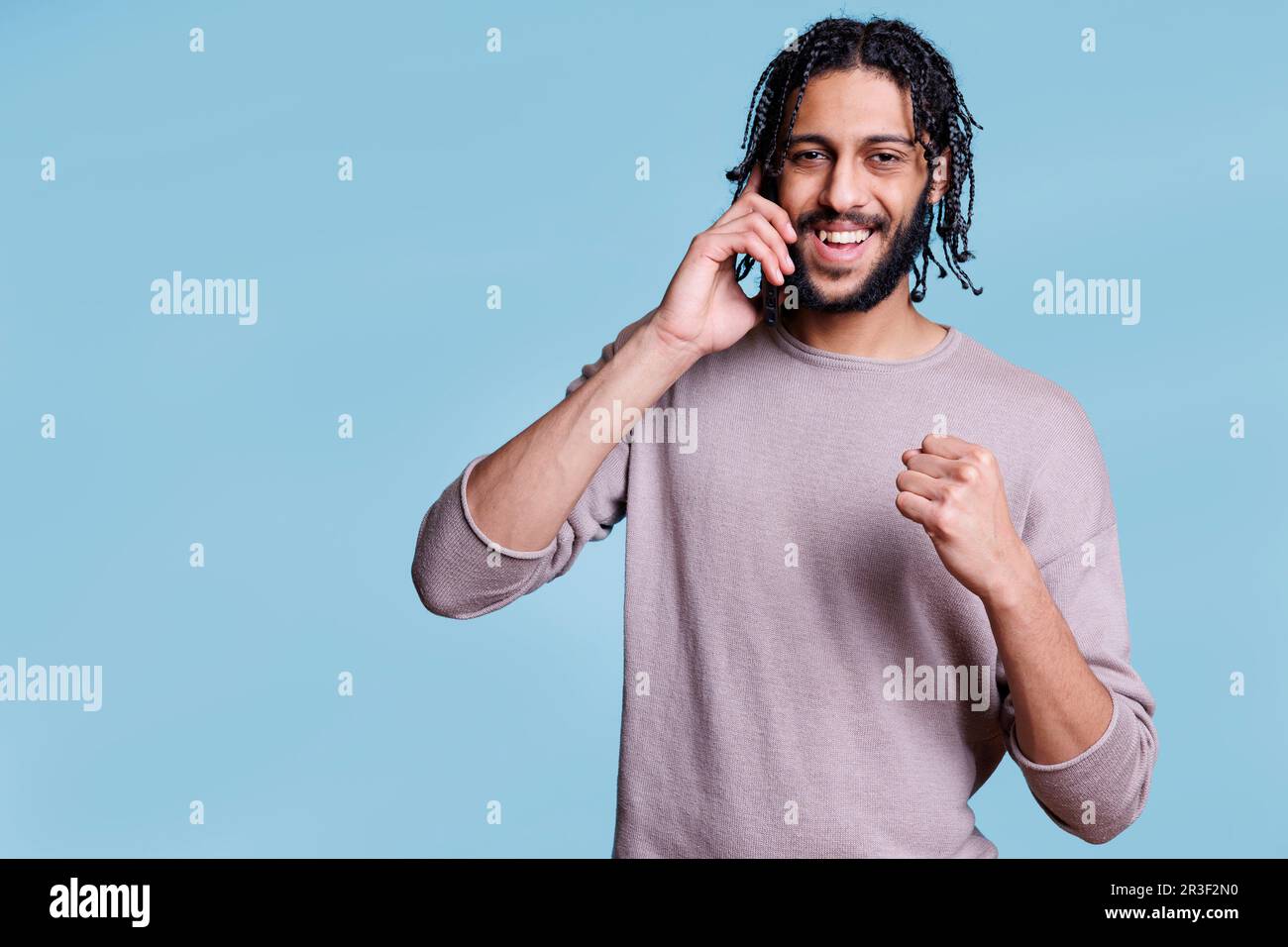 Happy man talking on smartphone and showing winner gesture Stock Photo ...