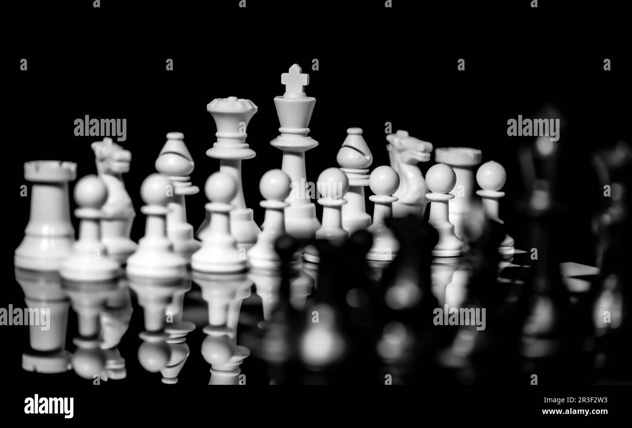 Close up of Chess pieces on a reflective mirror board surface with ...