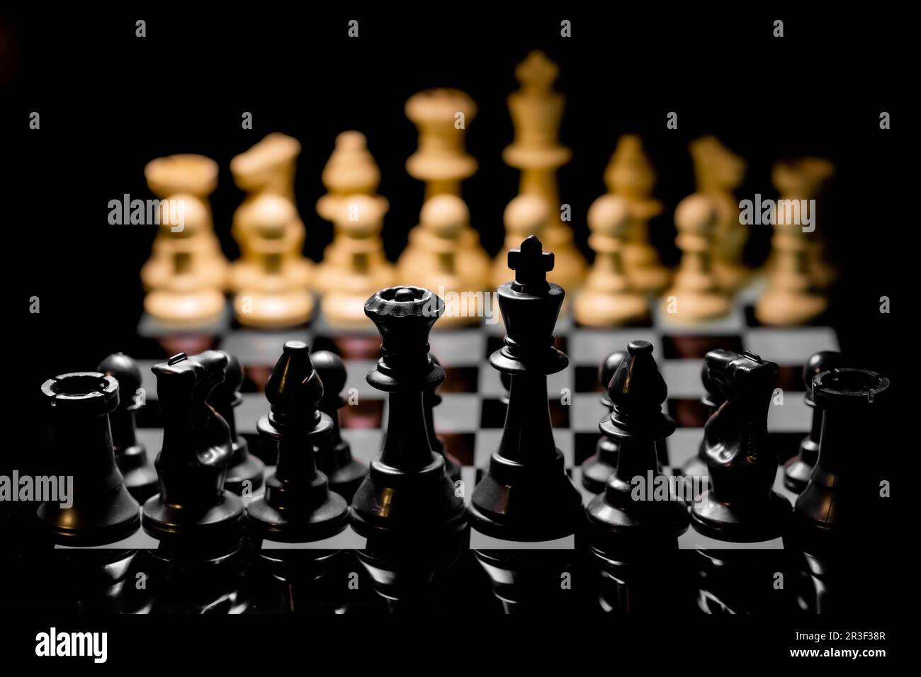 Close up of Chess pieces on a reflective mirror board surface with ...