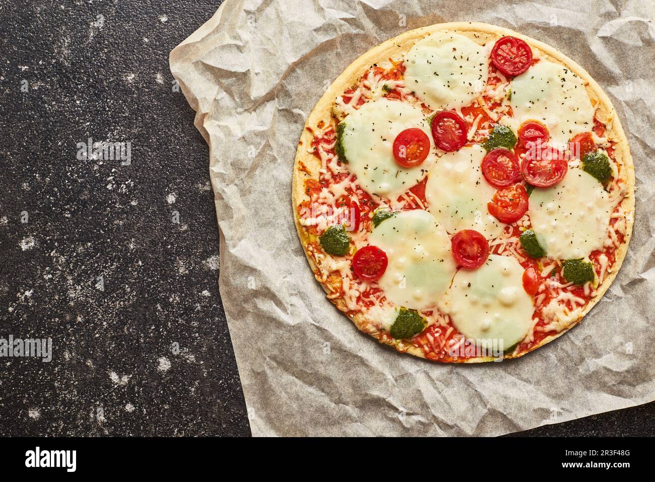 Fast food baked frozen pizza with cheese, tomatoes and pesto. Ready to ...