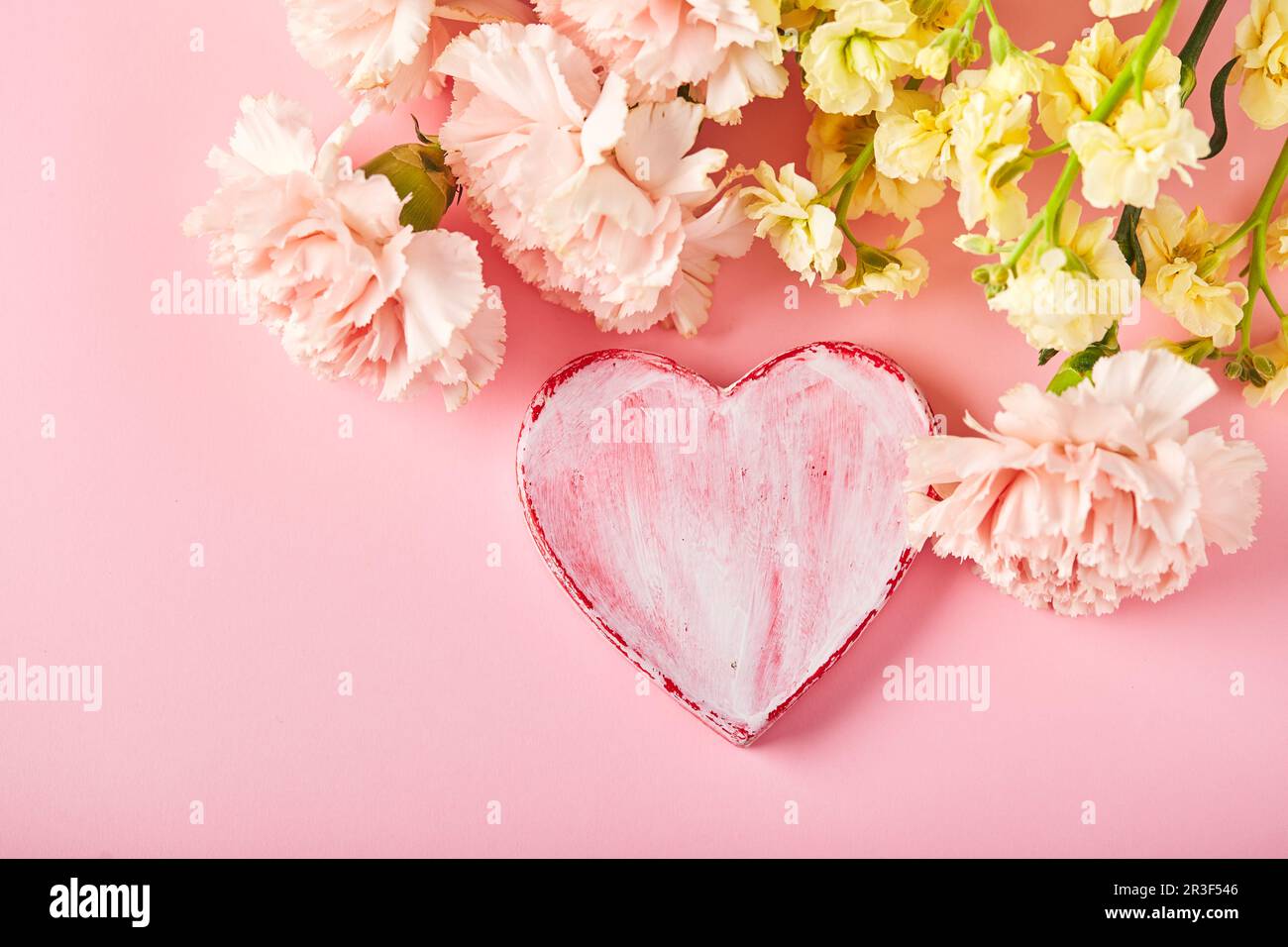 Bouquet of pink carnations and yellow matthiola with decorative heart ...