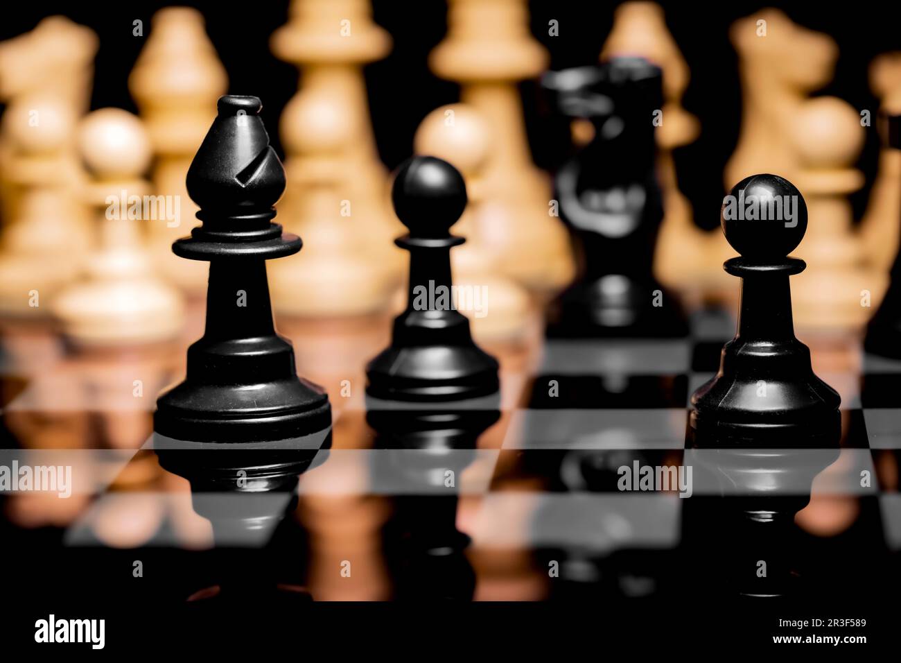Close up of Chess pieces on a reflective mirror board surface with ...