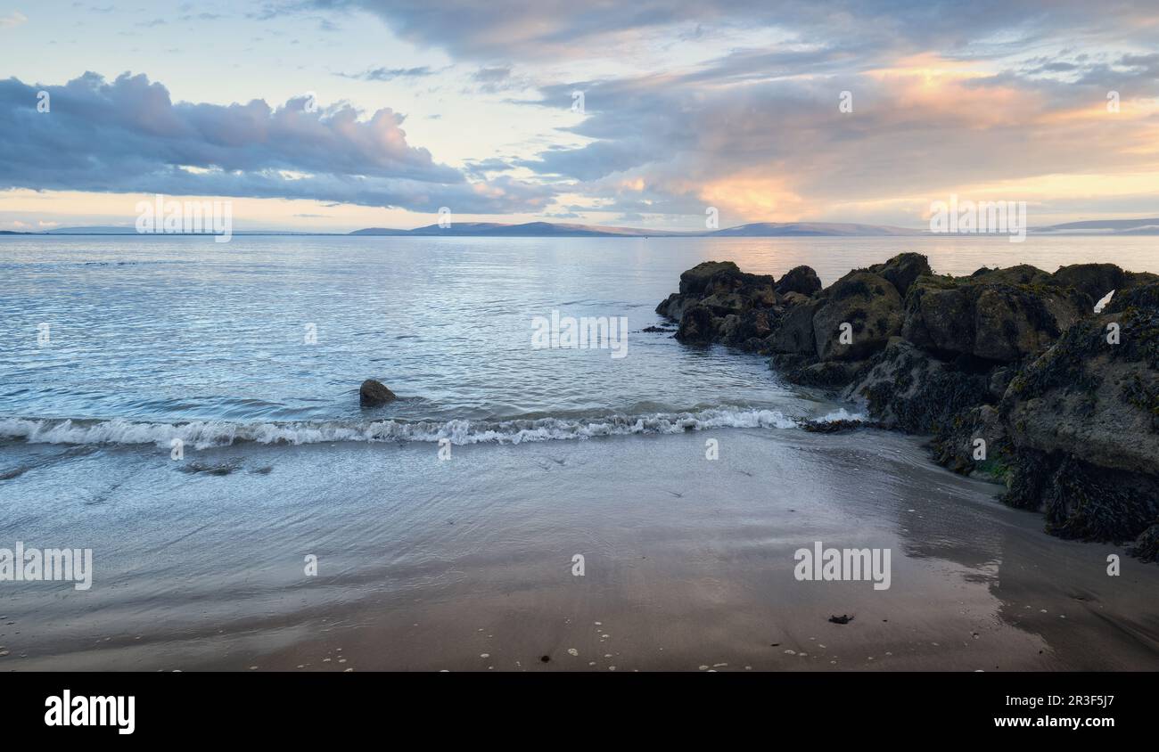 Beautiful sunset seascape scenery with rocks and stones on sandy ...