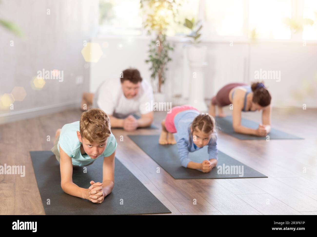 Family with two children doing pilates in studio Stock Photo - Alamy