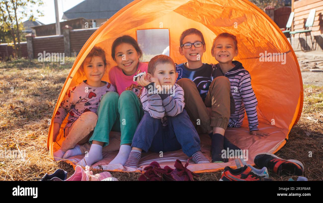 Happy kids - boys and girls in a tent outdoor Stock Photo - Alamy