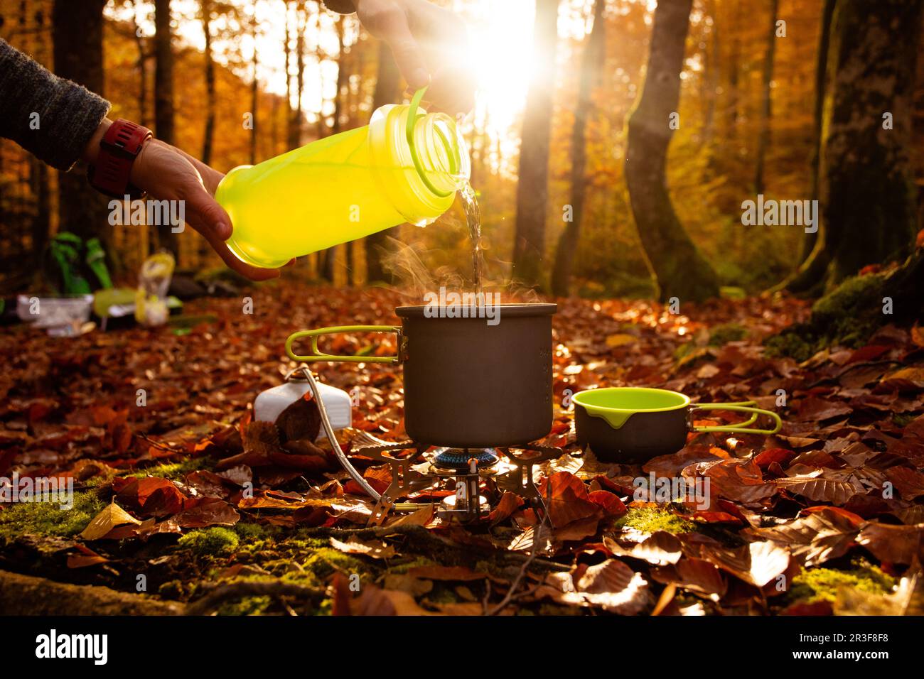 Woman flow water from collapsible bottle to a portable pan Stock Photo ...