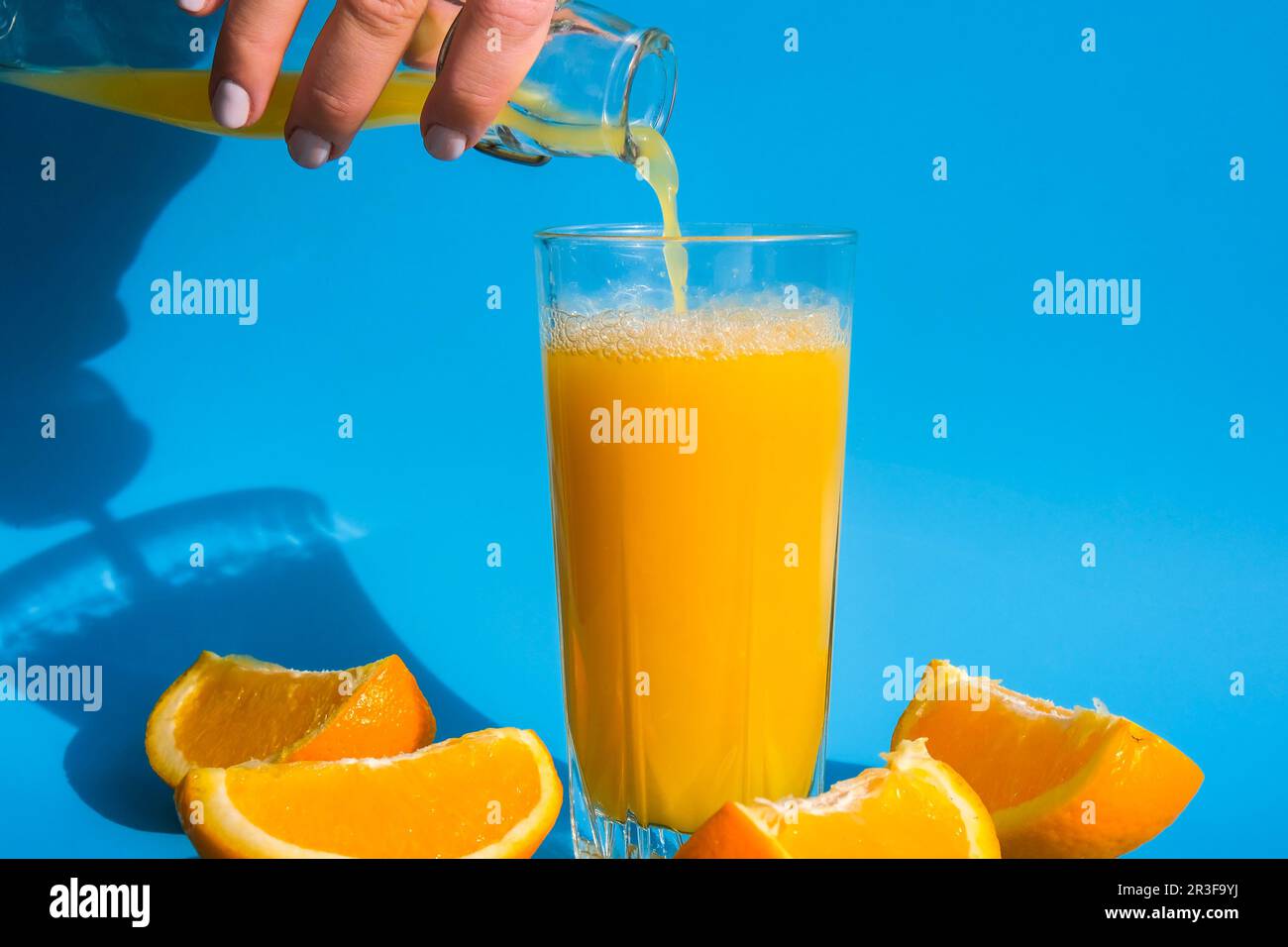 Pouring orange juice stream from jug into glass of squeezing Orange ...