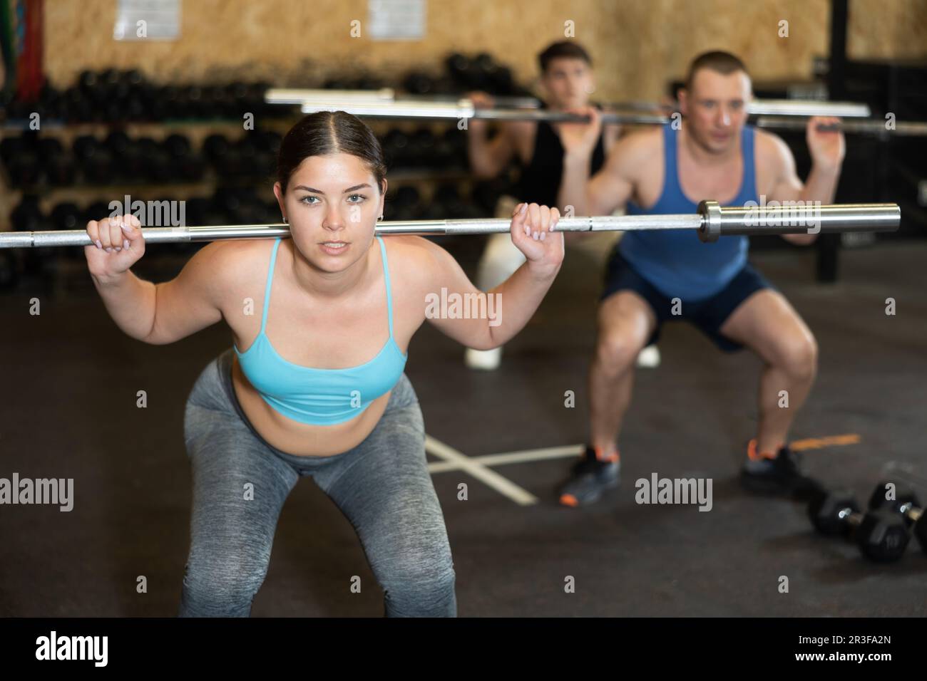 Young female bodybuilder performing strength and endurance exercises ...