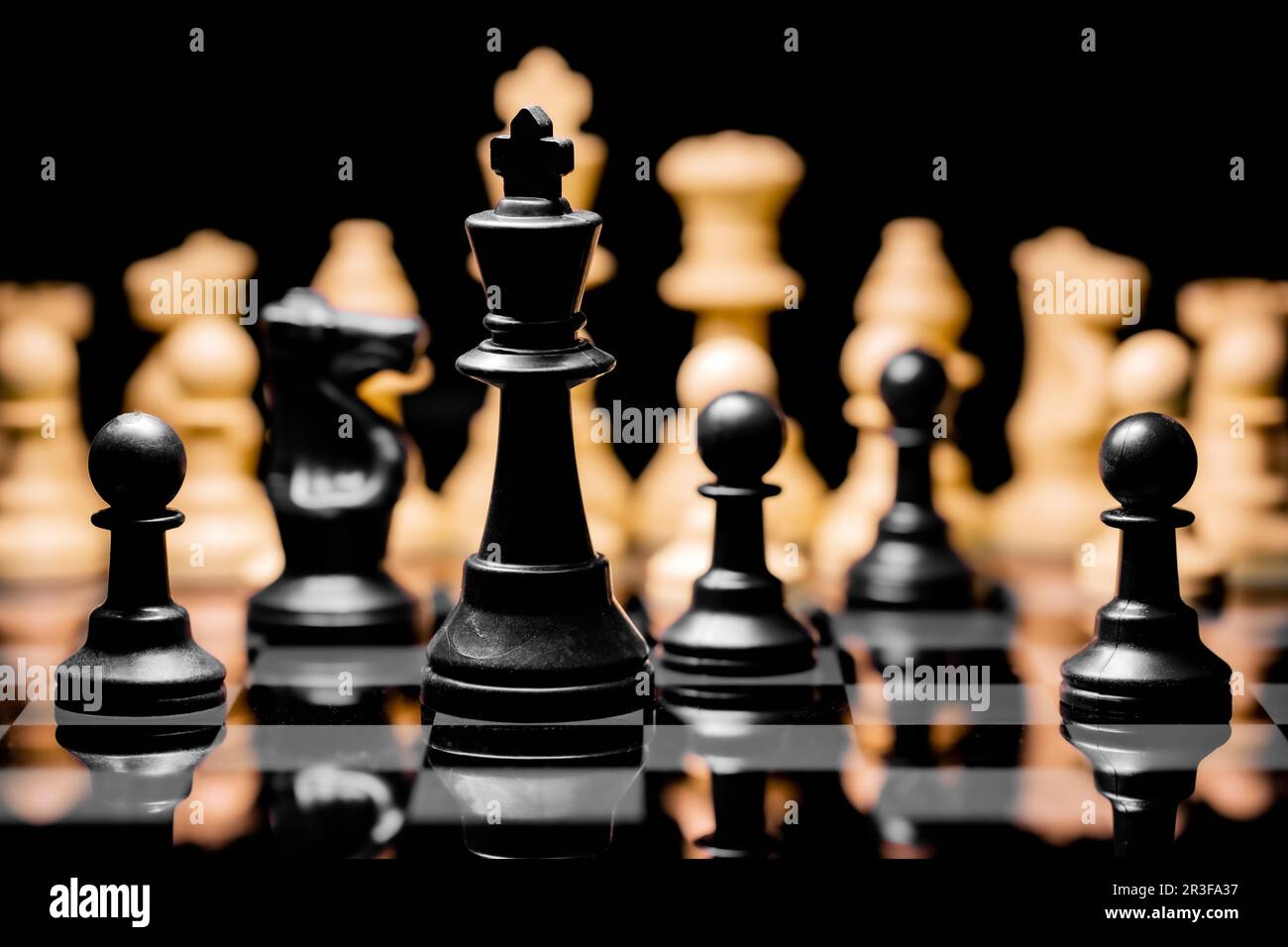 Close up of Chess pieces on a reflective mirror board surface with ...