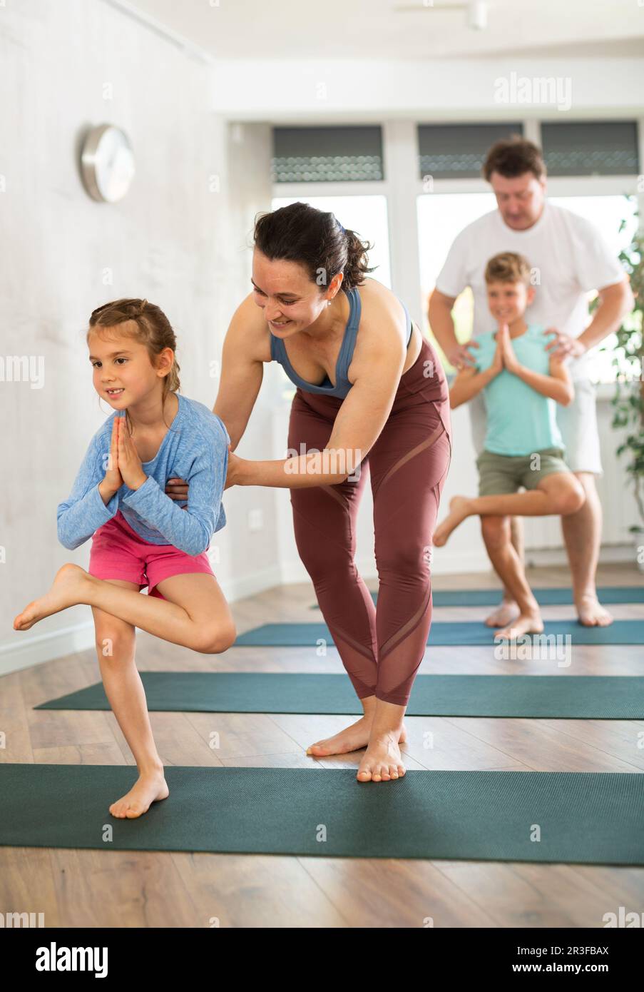 Parents help children to do pilates exercise in studio Stock Photo - Alamy