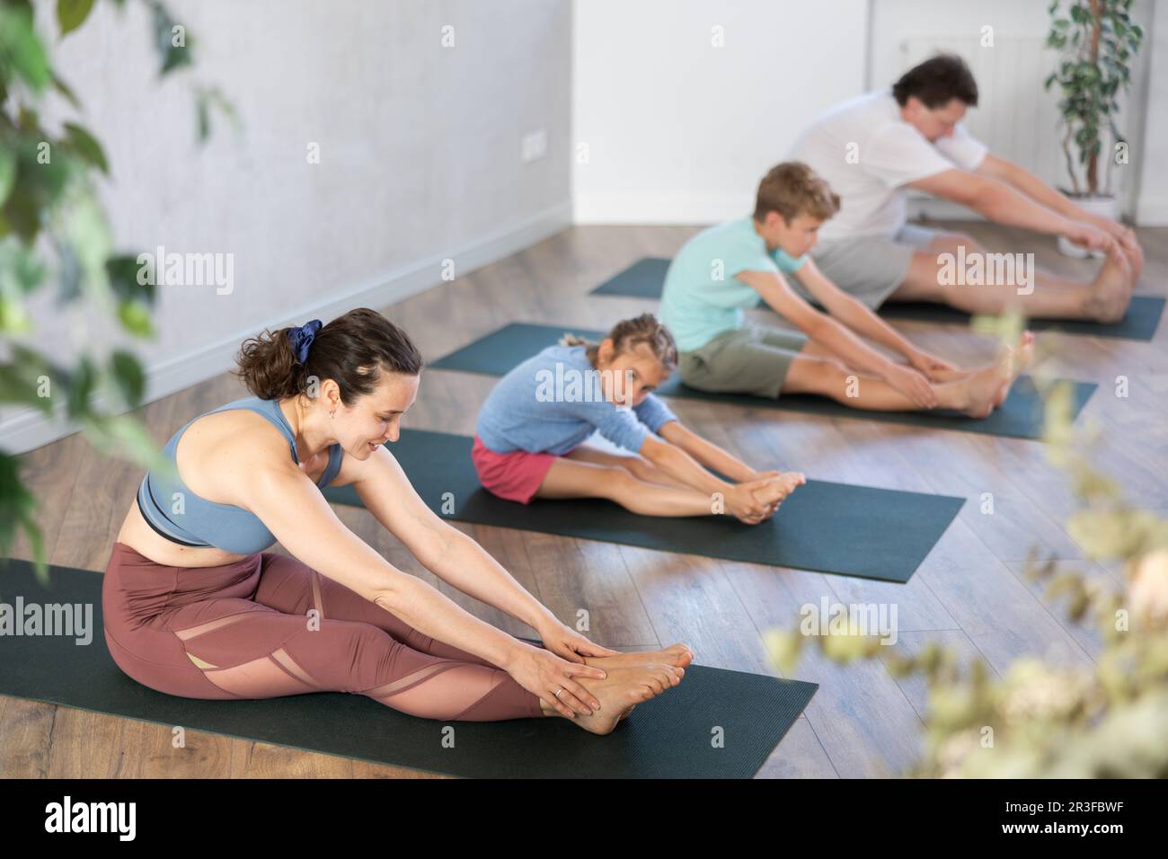 Family with two children doing pilates in studio Stock Photo - Alamy