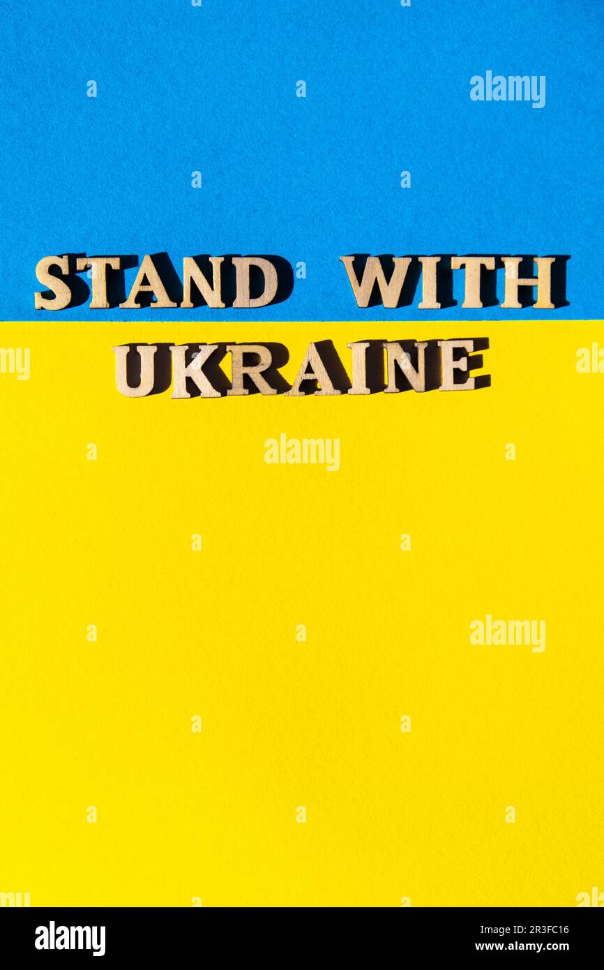 Ukrainian national flag made of paper. STAND WITH UKRAINE text. Stop ...