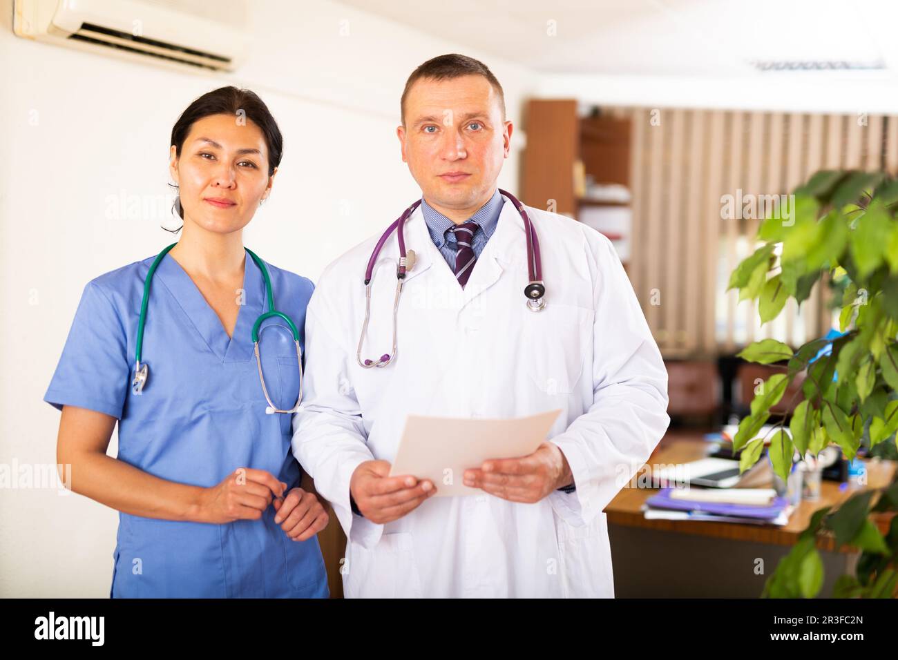 Two doctors checking patient papers in clinic Stock Photo - Alamy