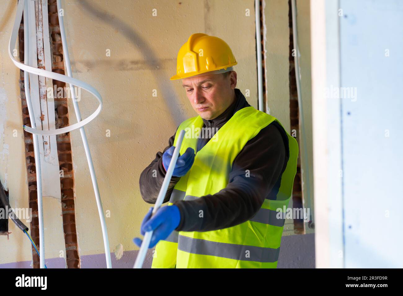 Electrician looking through cable duct Stock Photo - Alamy