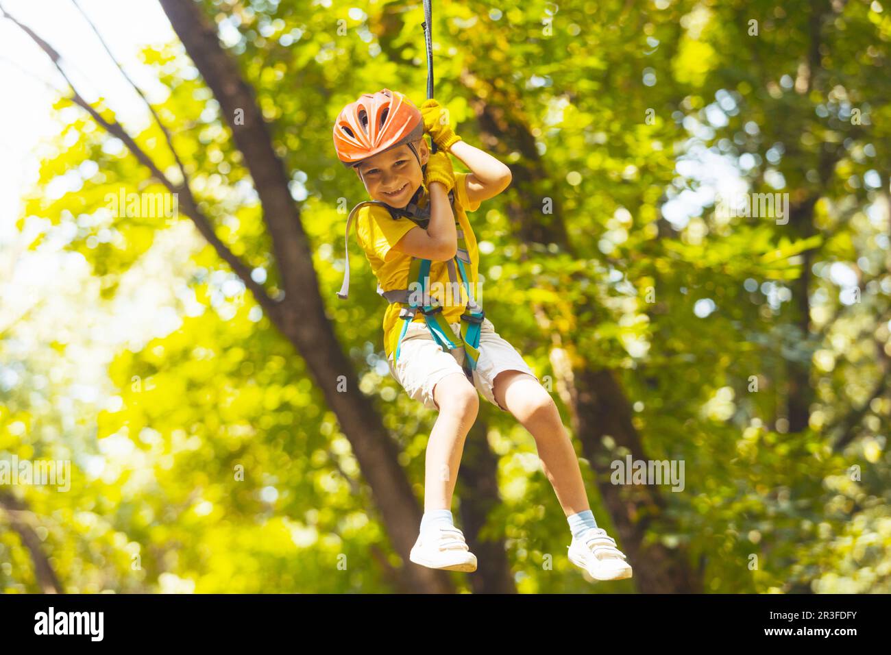 The little boy goes down the zipline in the park Stock Photo - Alamy