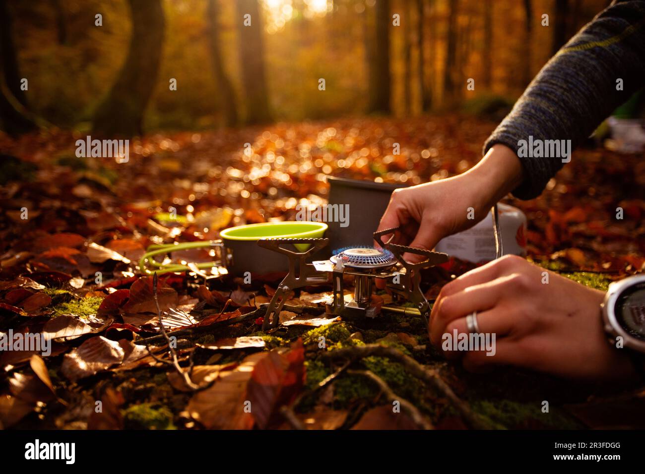 Woman uses portable gas heater and pan for cooking outdoors Stock Photo ...