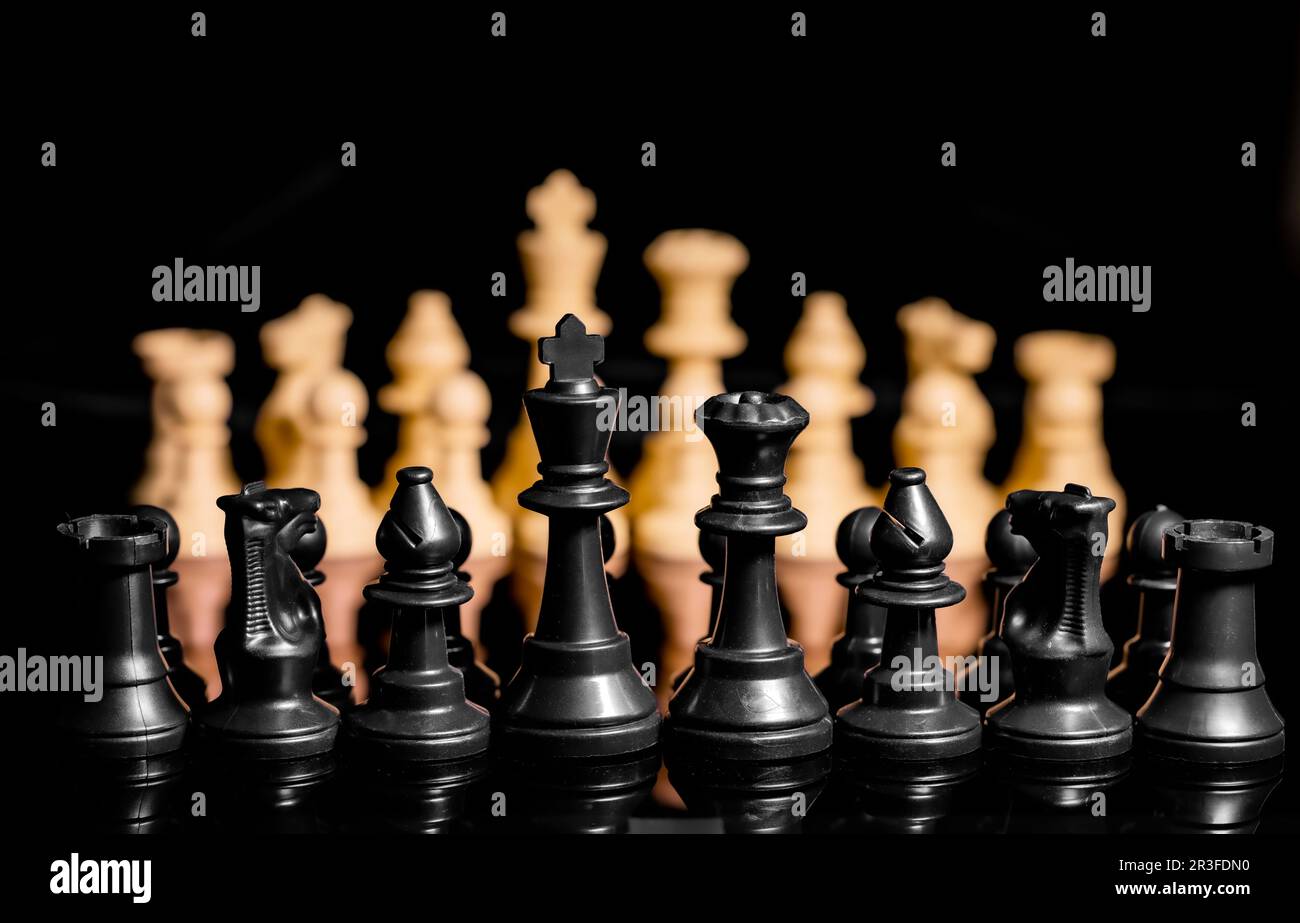 Close up of Chess pieces on a reflective mirror board surface with ...