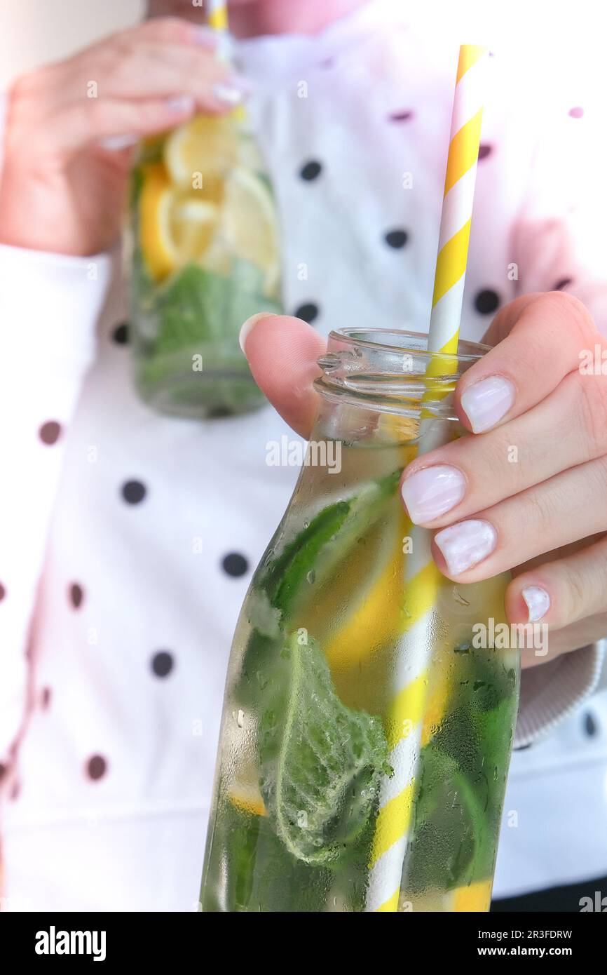 Female hand holding Mojito refreshing cocktail with eco paper drinking ...