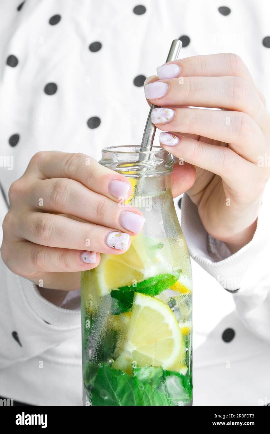 Female hand holding Mojito refreshing cocktail with eco metal drinking ...