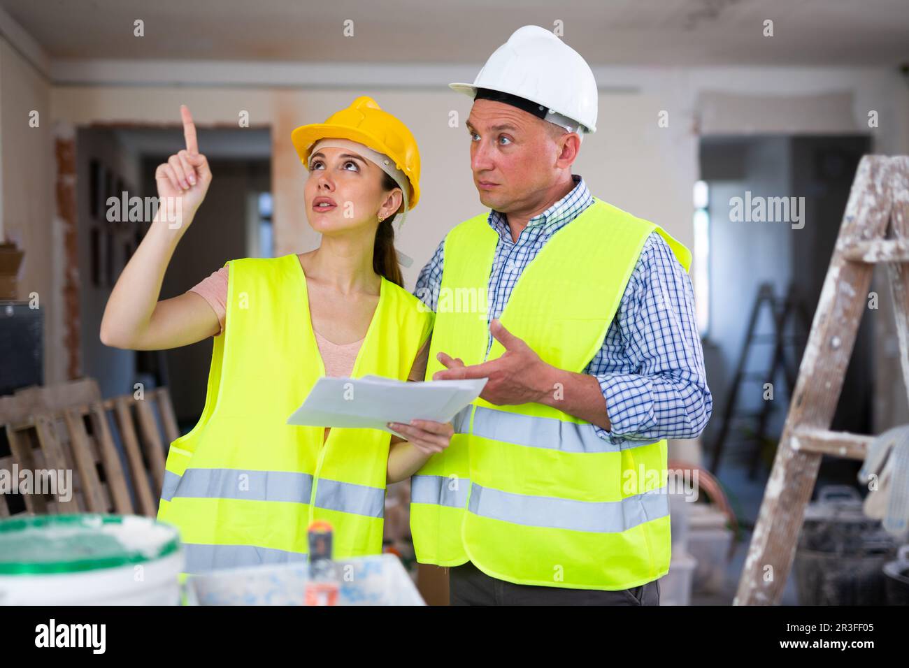 Man and woman builders talking in house Stock Photo - Alamy