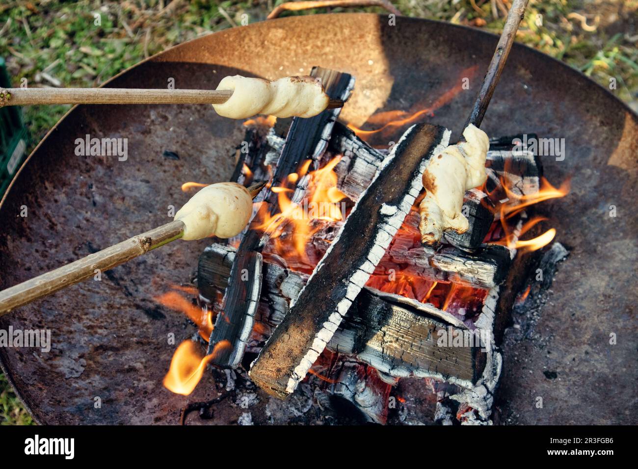 Prepare stick bread at the campfire Stock Photo - Alamy