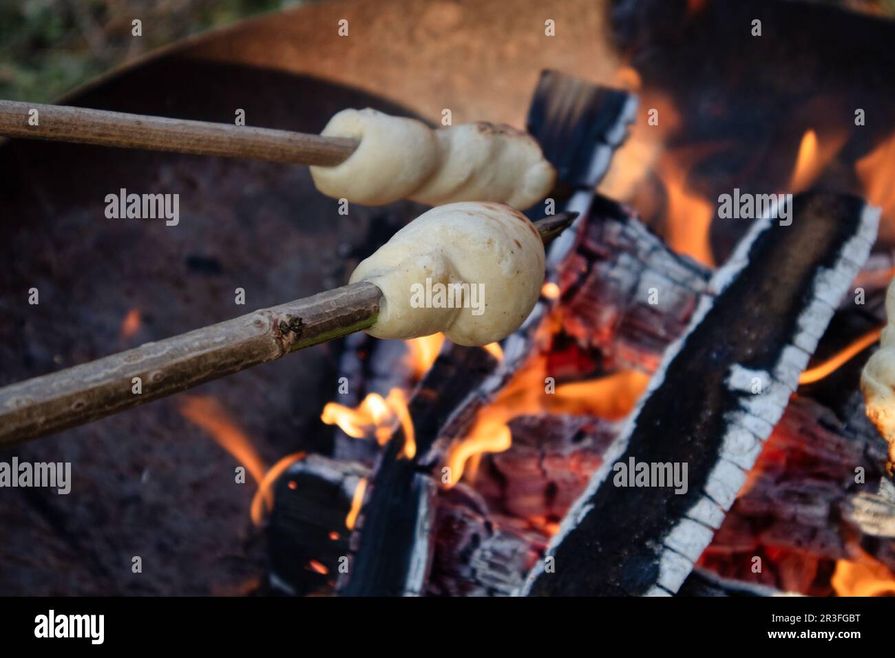 Prepare stick bread at the campfire Stock Photo - Alamy