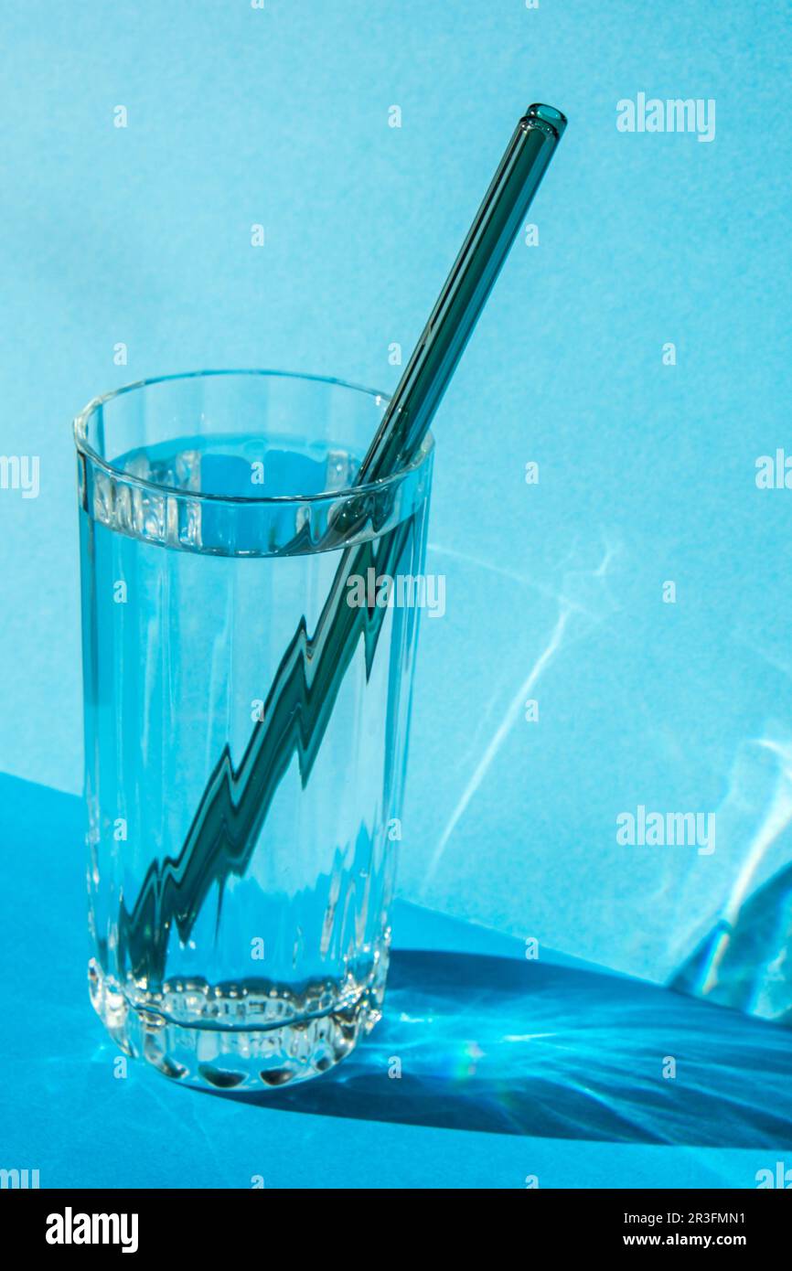 Reusable glass Straws in Glass with water on blue background Eco ...
