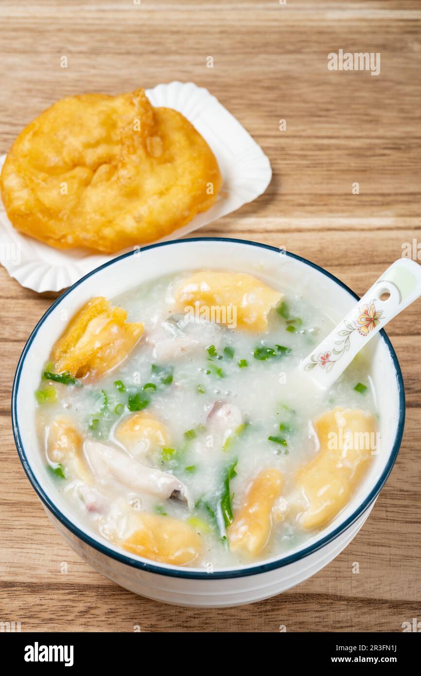 angle view fish porridge with deep-fried Chinese donuts at vertical ...