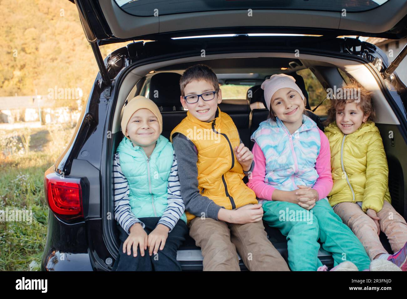 Mom and little boy sitting in hatchback car with mountain background ...