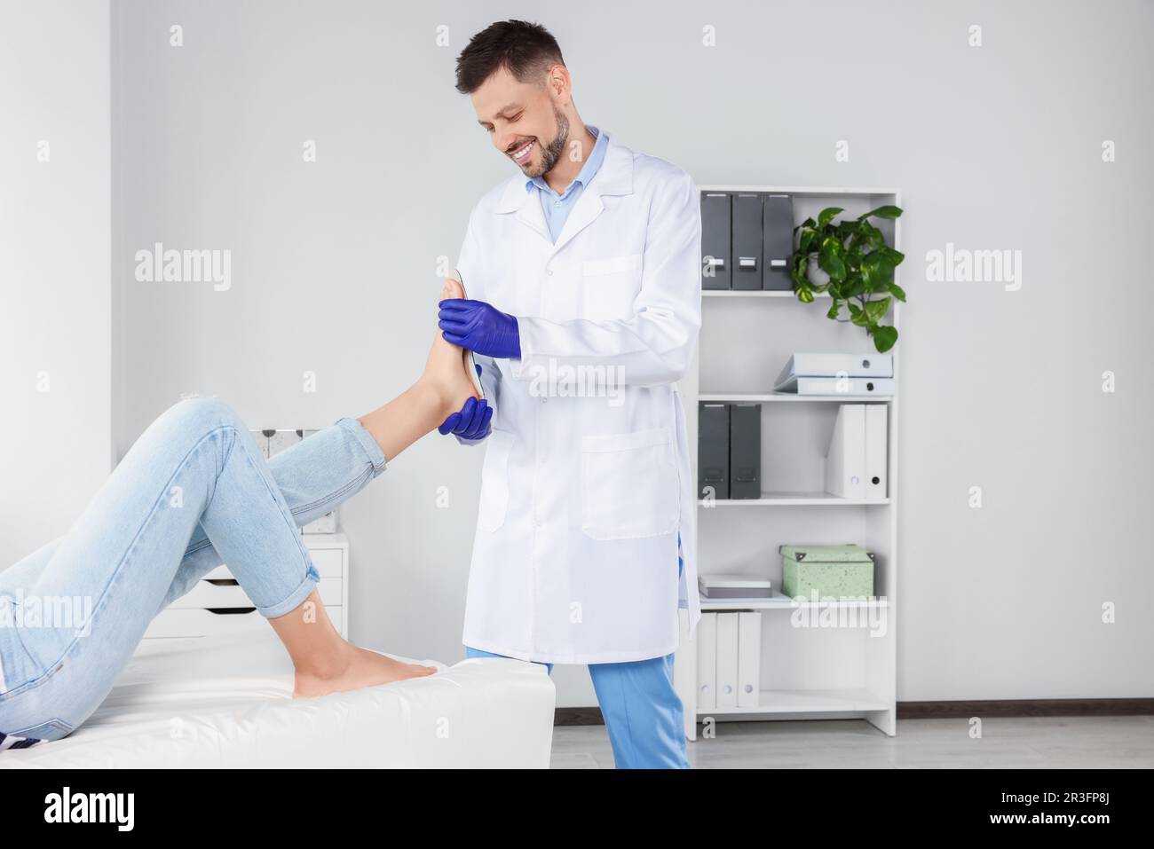 Male orthopedist fitting insole to patient's foot in hospital Stock ...