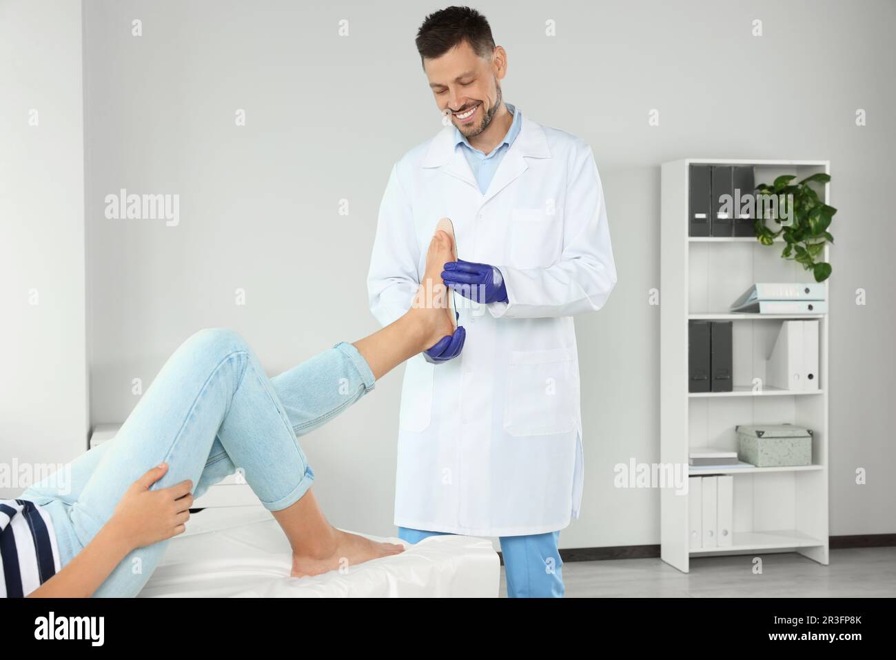 Male orthopedist fitting insole to patient's foot in hospital Stock ...