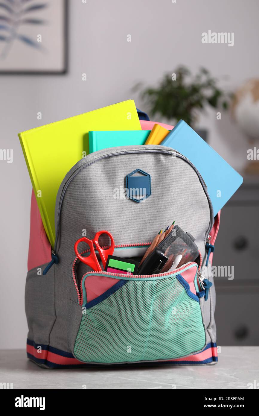 Children's backpack with different school stationery on table indoors ...