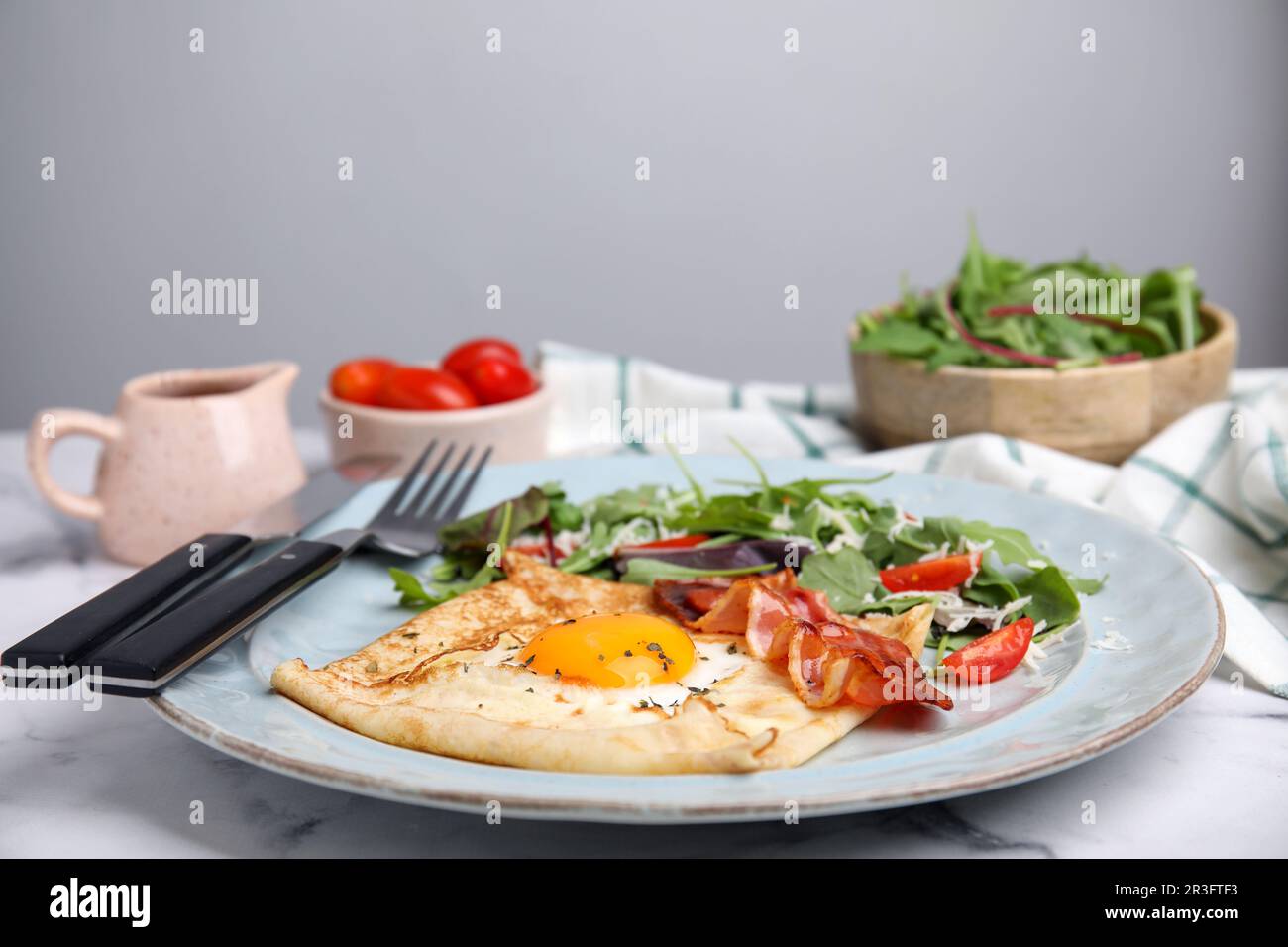 Delicious crepe with egg served on white marble table. Breton galette ...