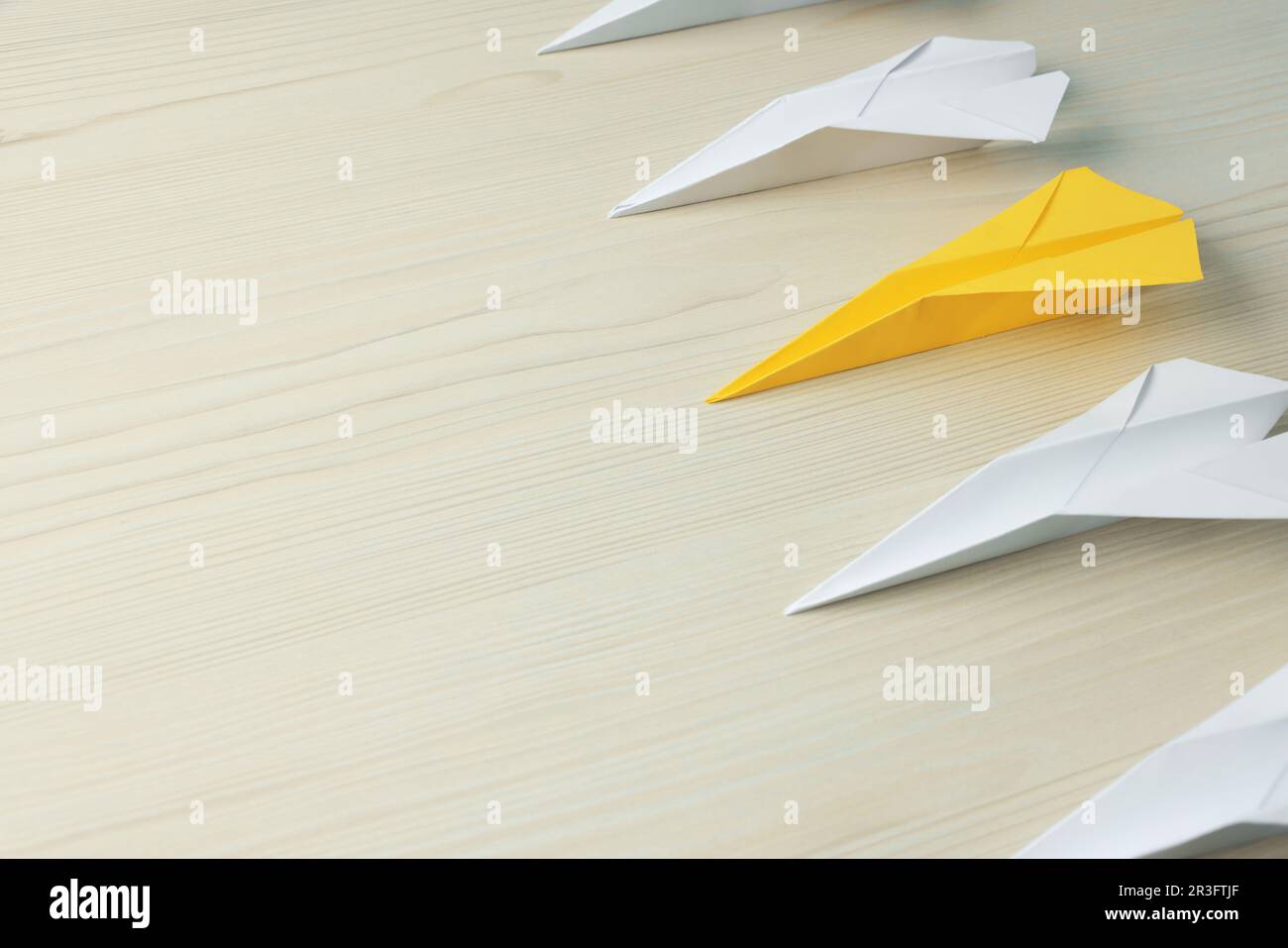 Handmade colorful paper planes on beige wooden table, space for text ...