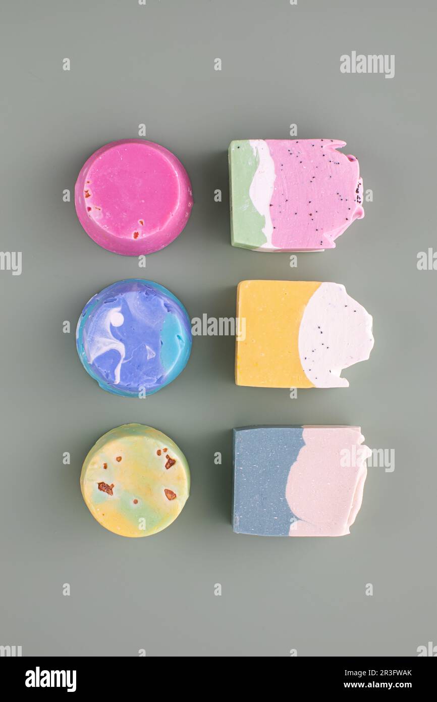 Pieces of different shapes and colors of handmade soap on a green ...