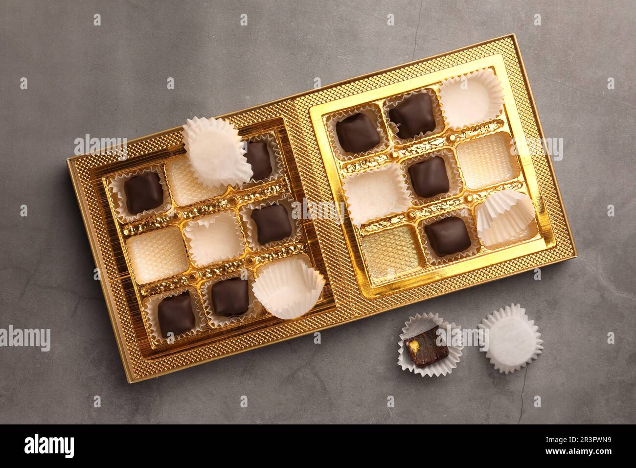 Partially empty box of chocolate candies on grey background, top view ...